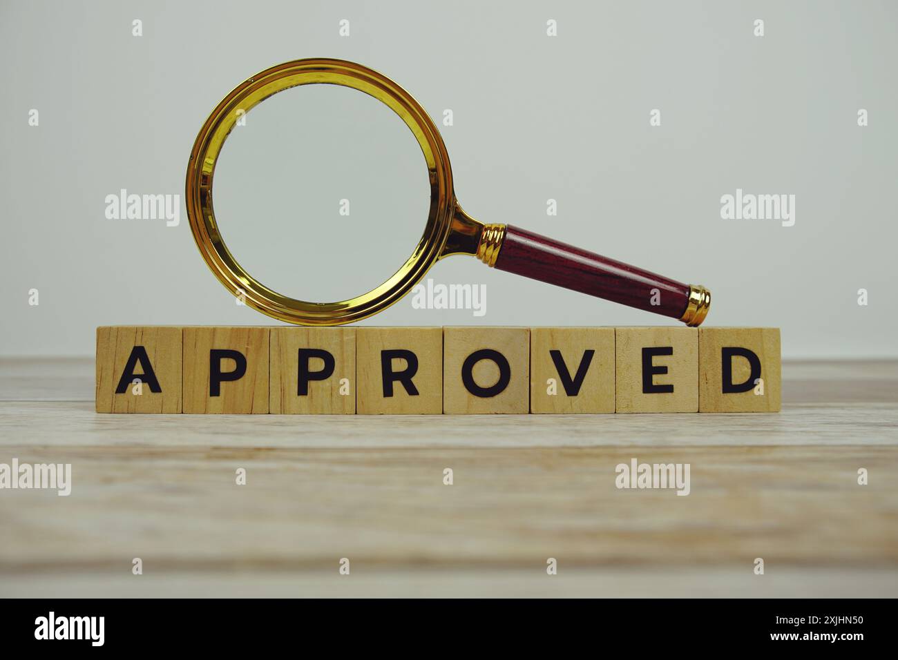 Magnifying glass with wooden blocks alphabet letters APPROVED on wooden ...