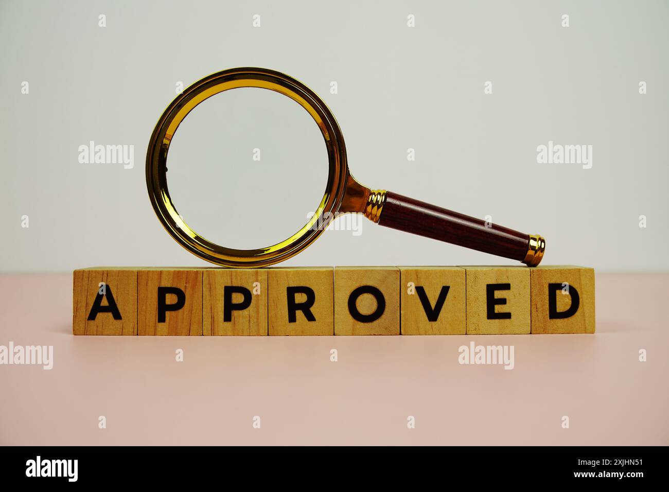Magnifying glass with wooden blocks alphabet letters APPROVED on pink ...