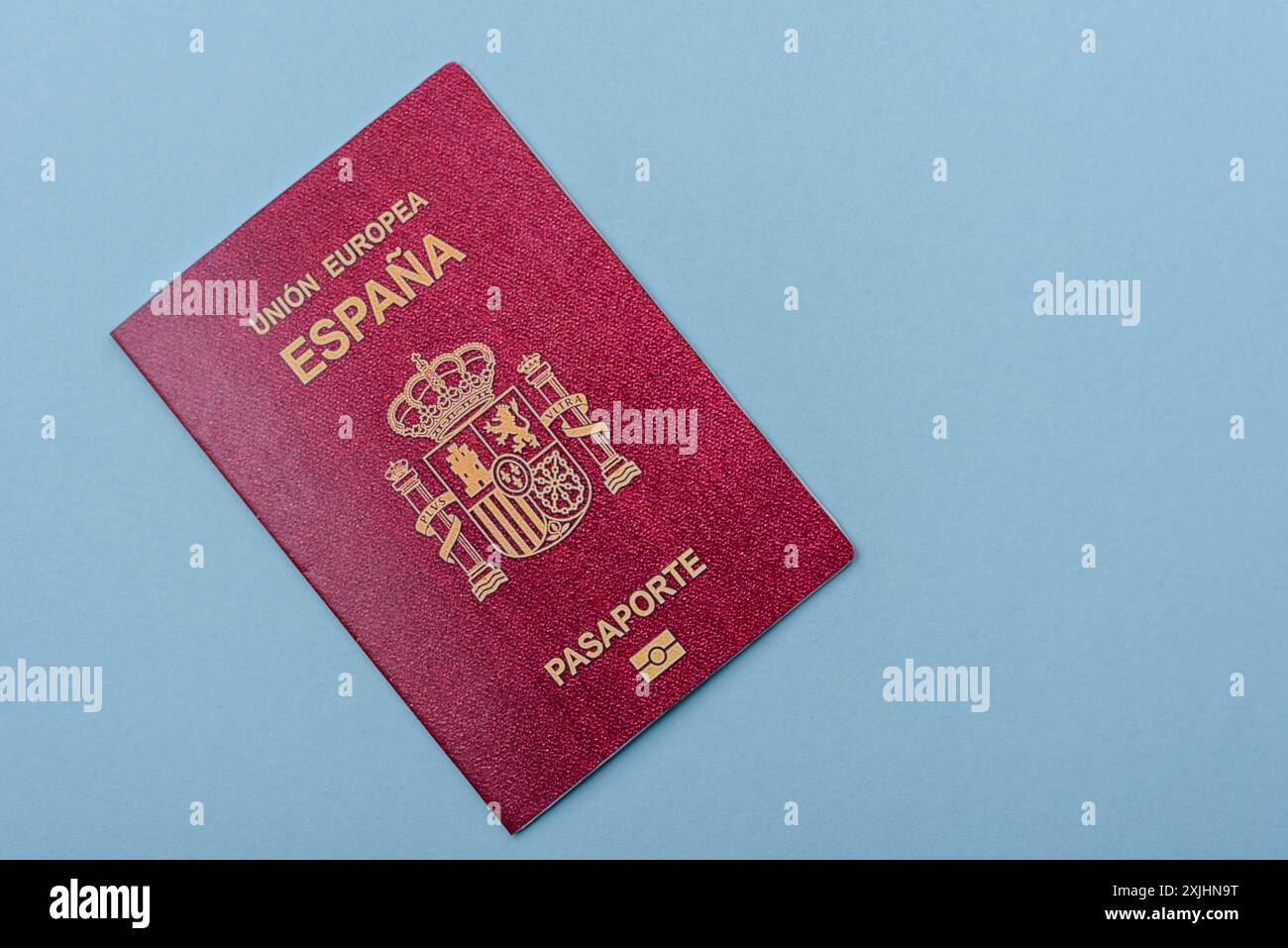 Physical paper international passport of a Spanish citizen on a blue ...
