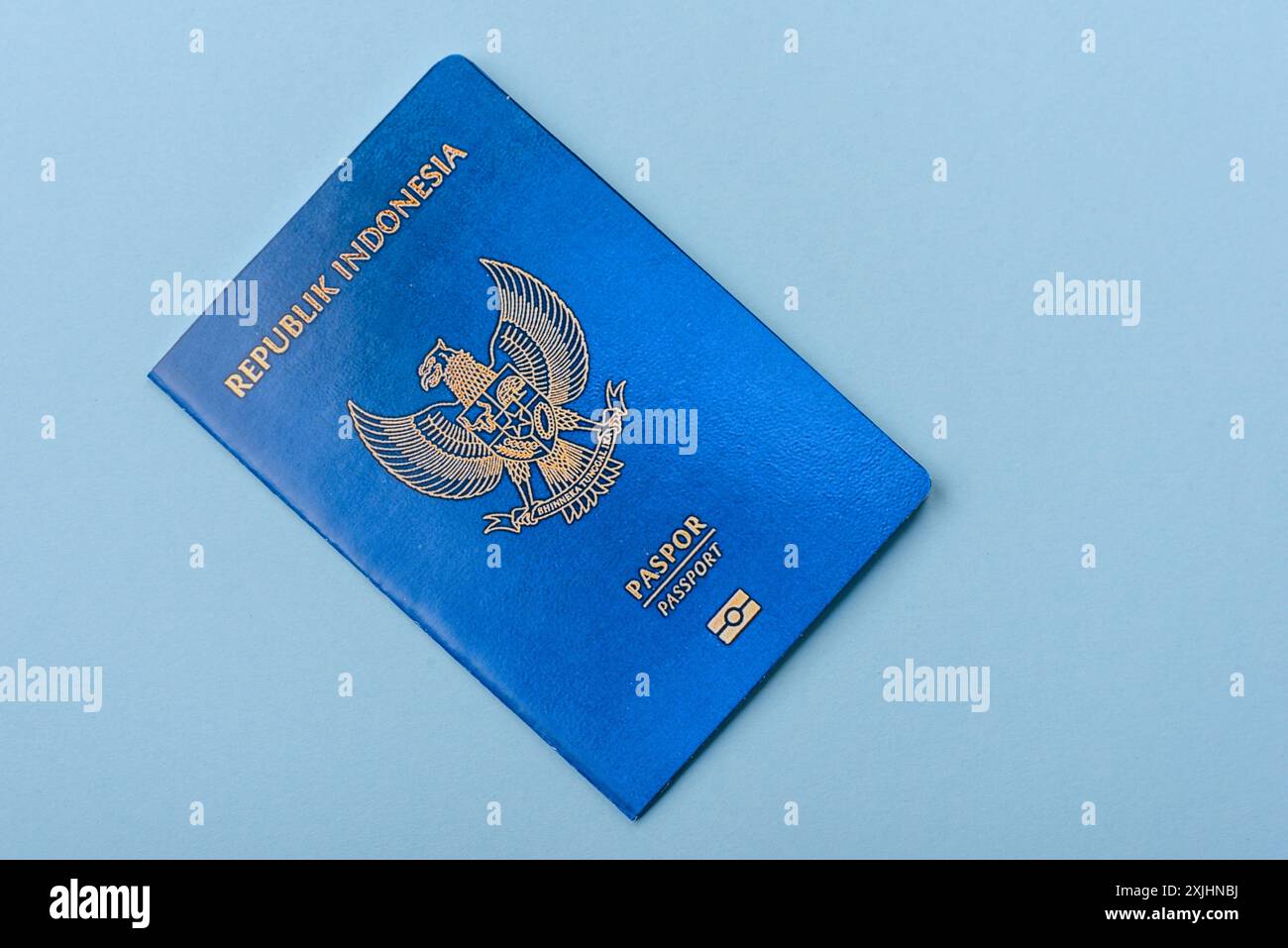 Physical paper international passport of Indonesian citizen on a blue ...