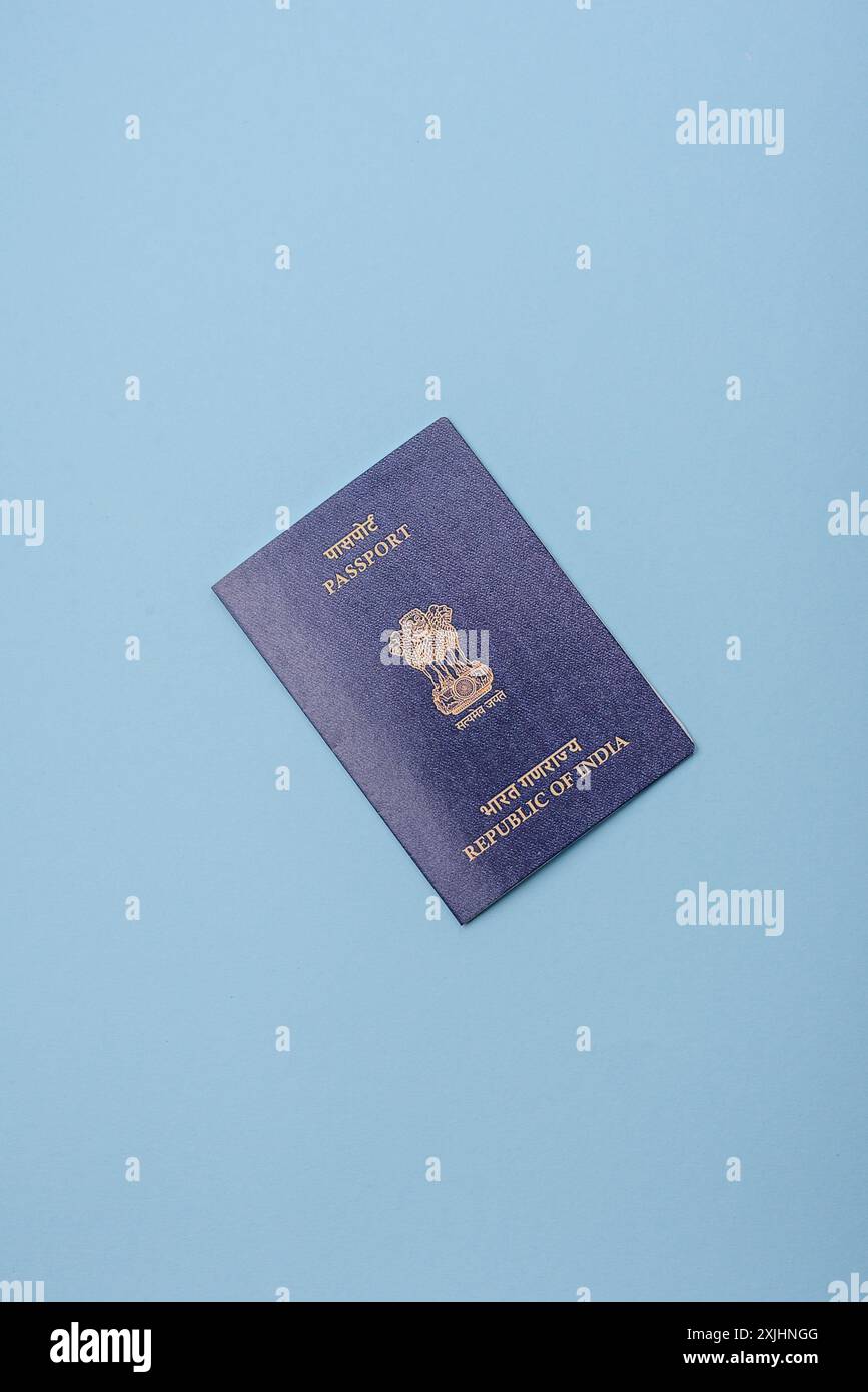 Physical paper international passport of Indian citizen on a blue ...