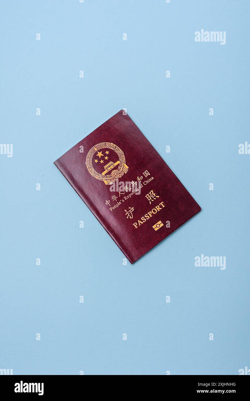 Physical paper international passport of a Chinese citizen on a blue ...