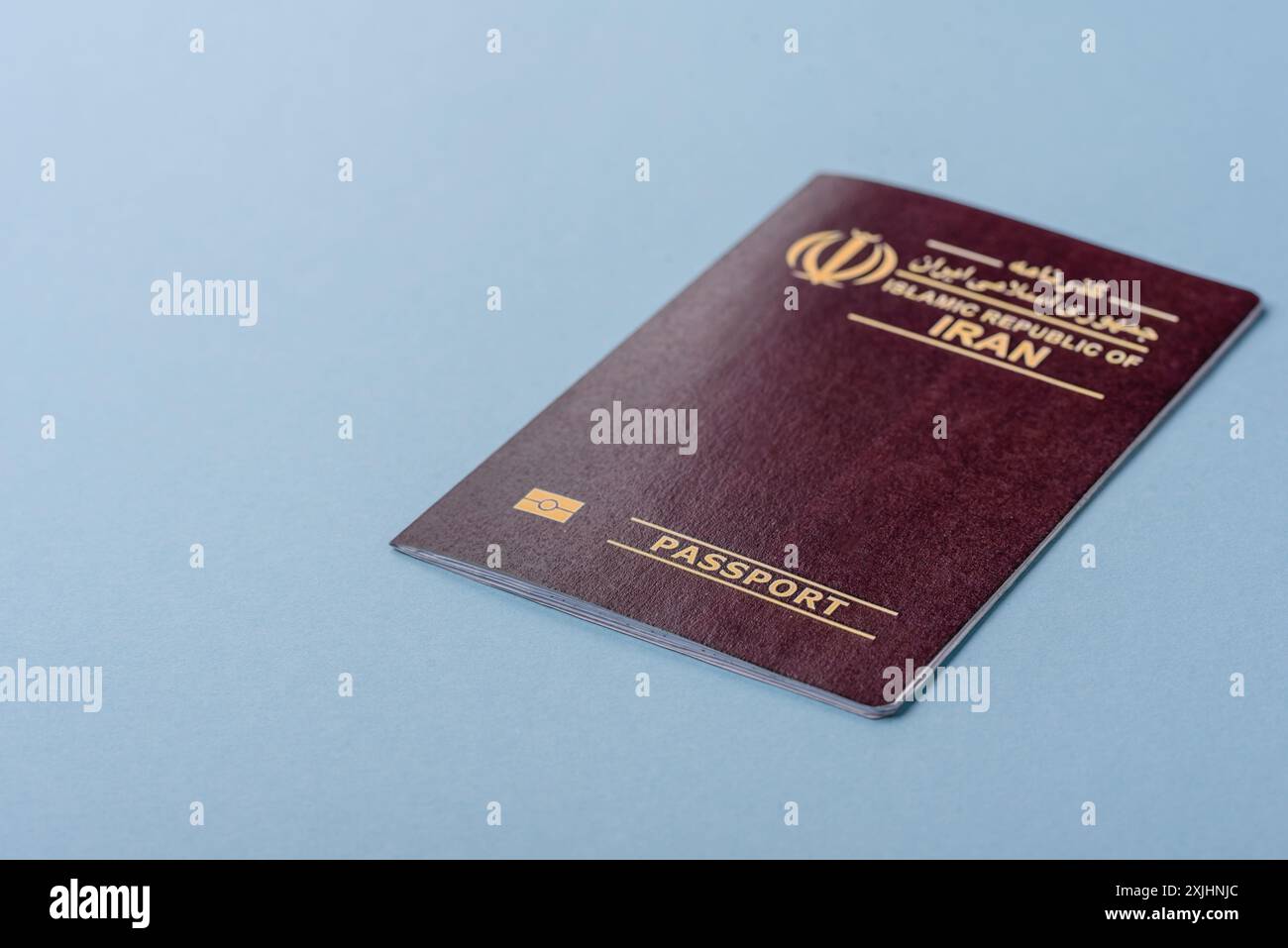 Physical paper international passport of Iranian citizen on a blue ...