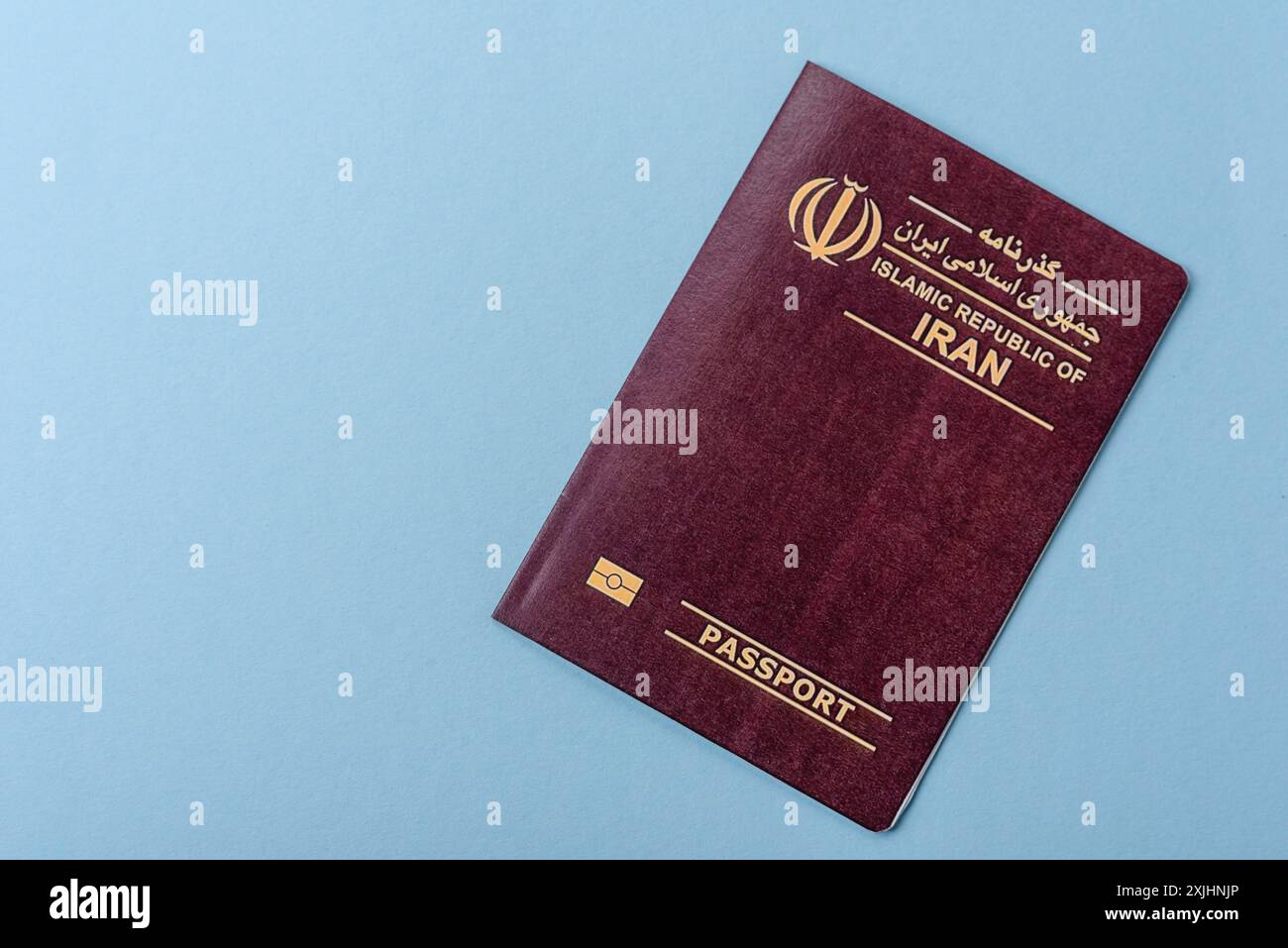 Physical paper international passport of Iranian citizen on a blue ...