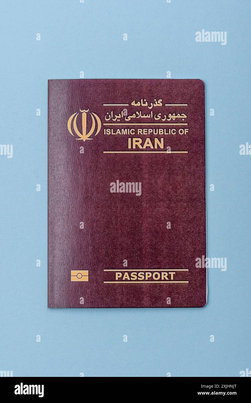 Physical paper international passport of Iranian citizen on a blue ...