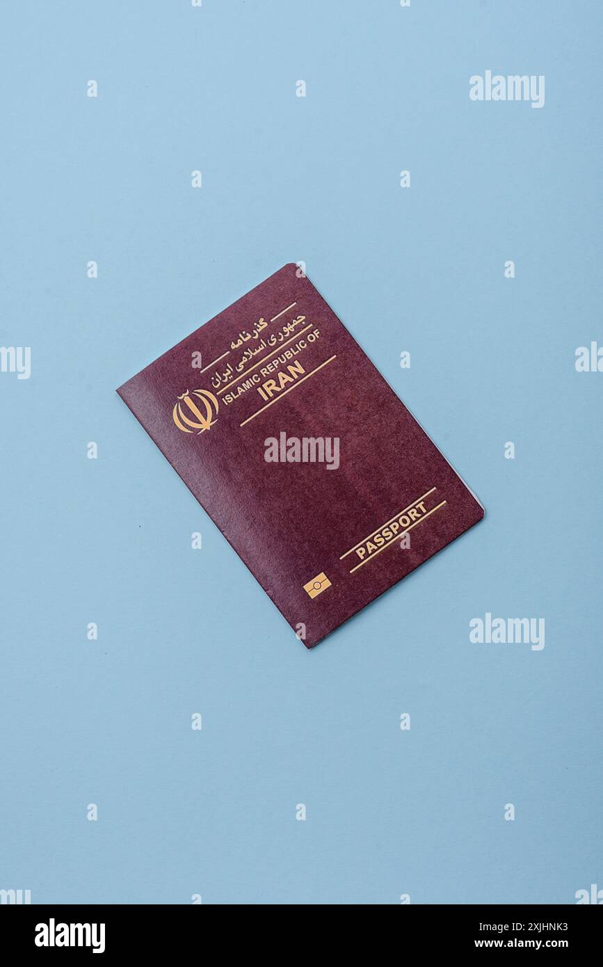 Physical paper international passport of Iranian citizen on a blue ...