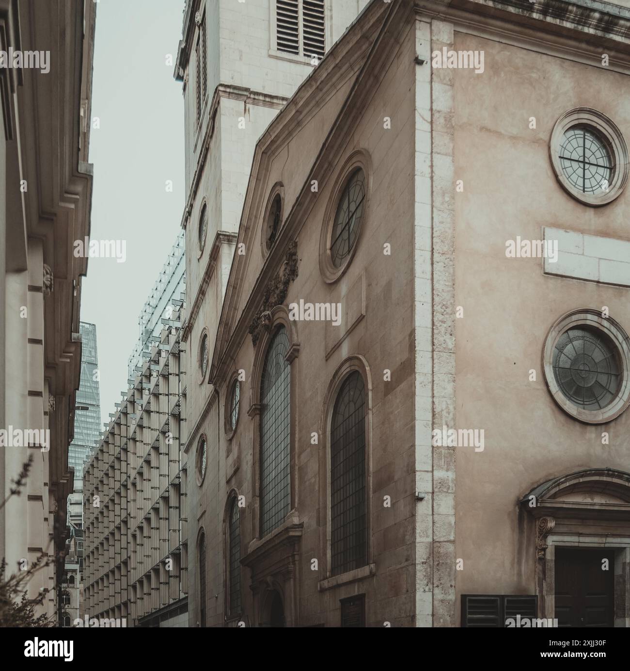 A historic building with arched windows and a tall, modern building ...