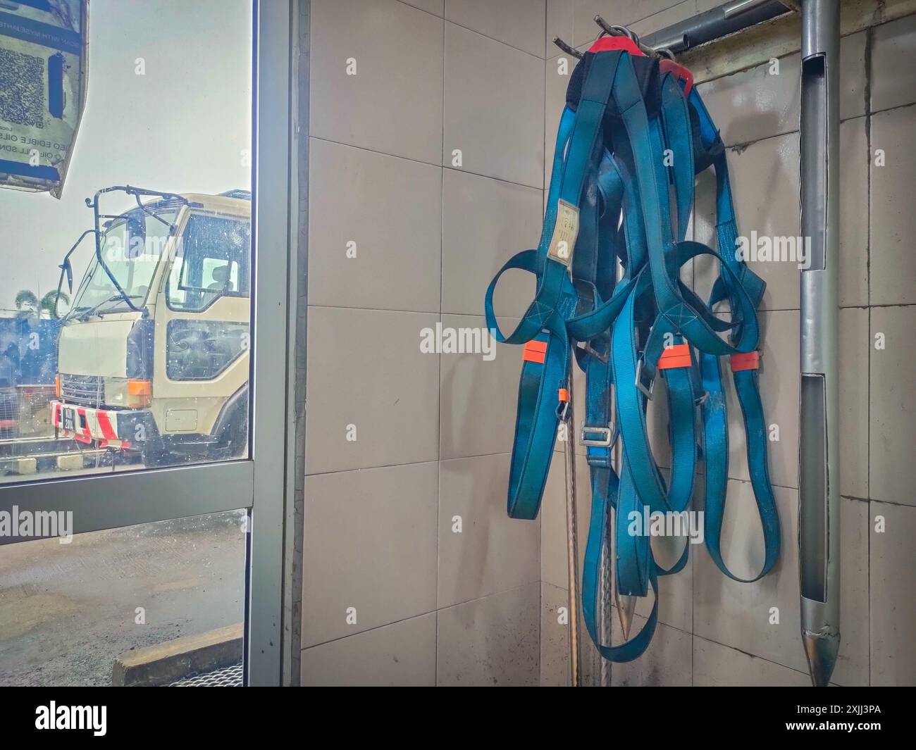 A blue safety harness is hung next to the sample taking equipment in a ...