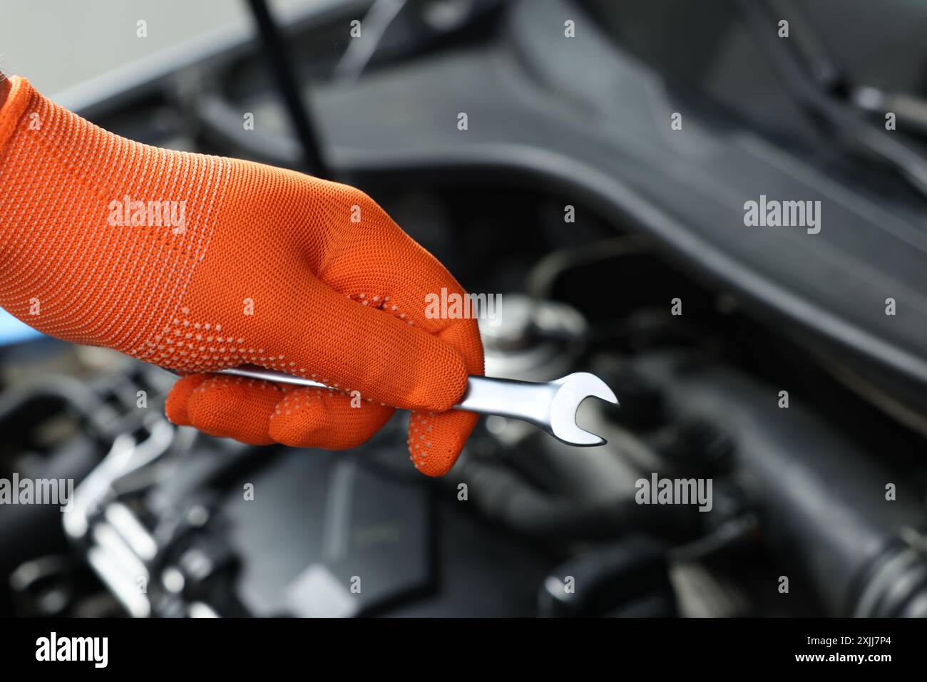 Auto mechanic with ratcheting wrench fixing car at automobile repair ...