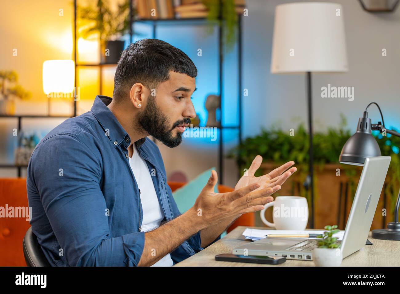 Angry furious Indian man freelancer using laptop while working at home ...