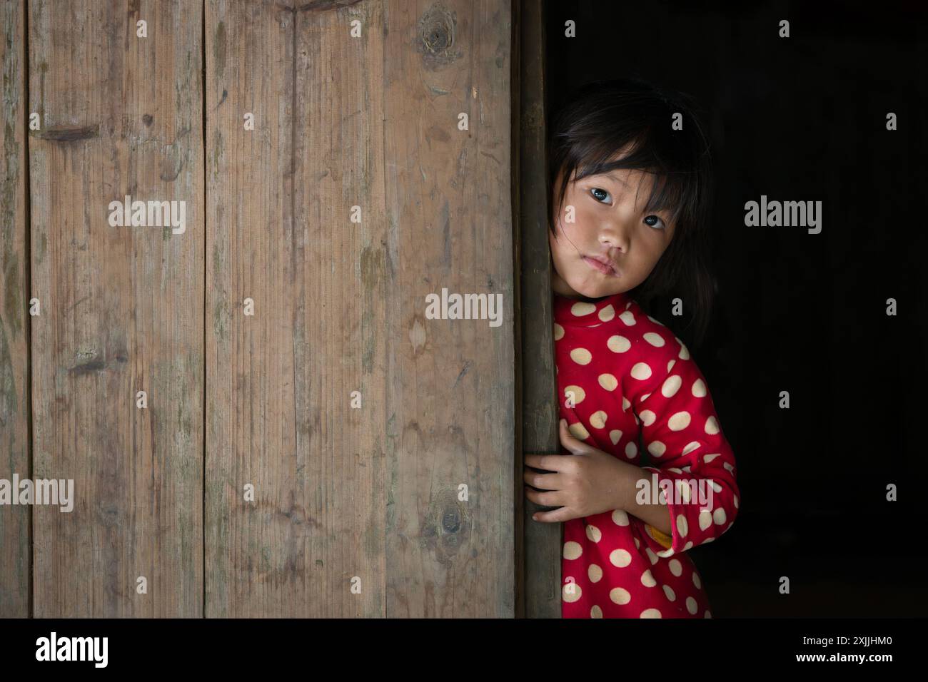 Young Hmong girl looking from behind a door, Lao Cai Province, Vietnam ...
