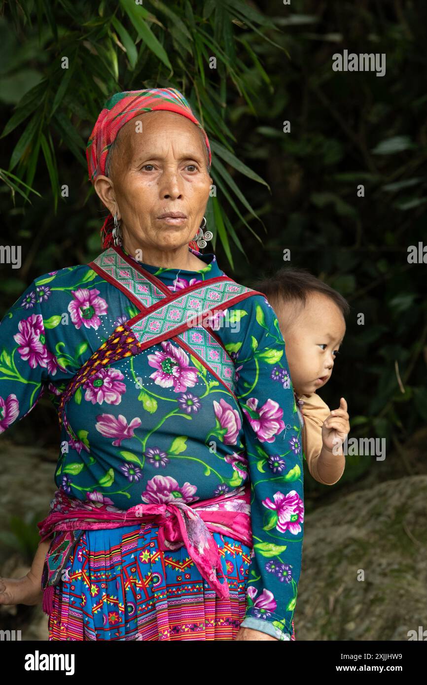 Hmong woman carrying a baby in Lao Cai Province, Vietnam Stock Photo ...