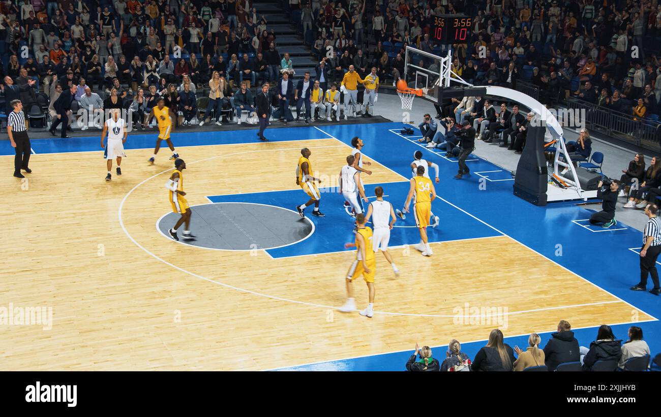 Basketball Championship in a Crowded Arena: Yellow Team Passing the ...