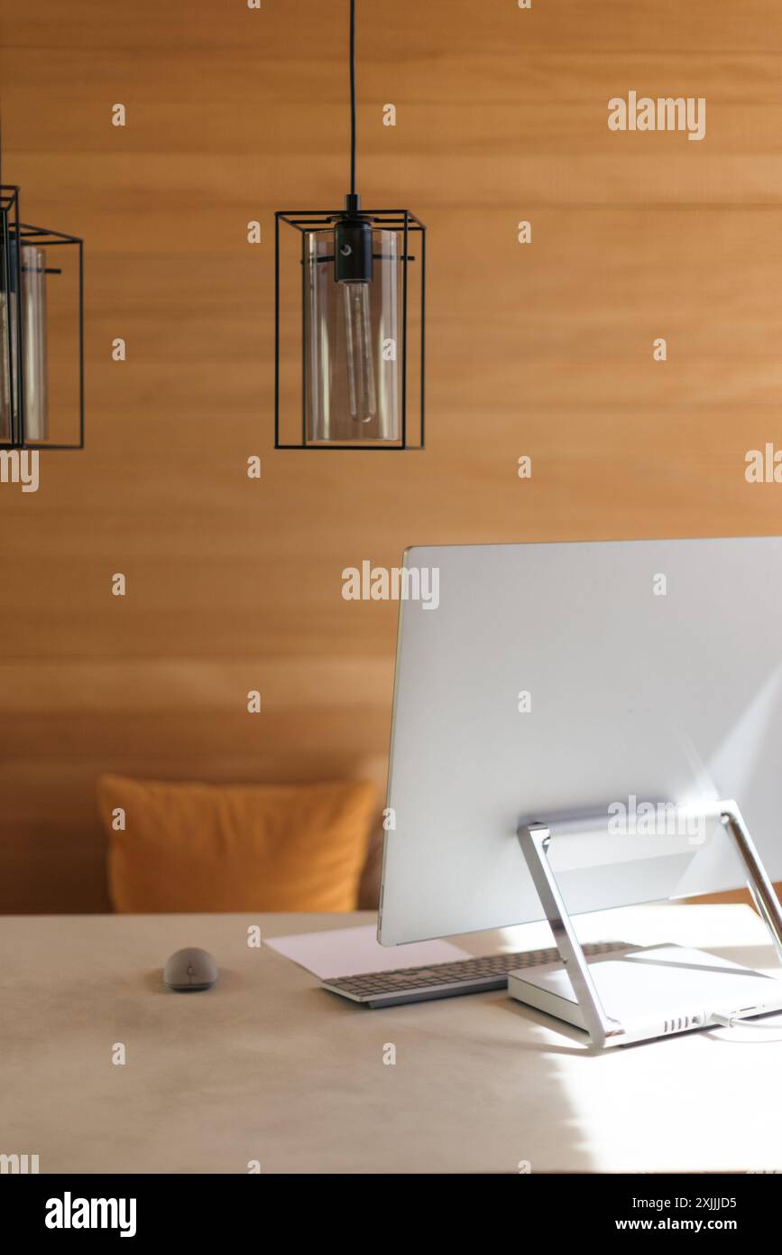 Modern workspace with computer, minimalist decor, and pendant lights ...