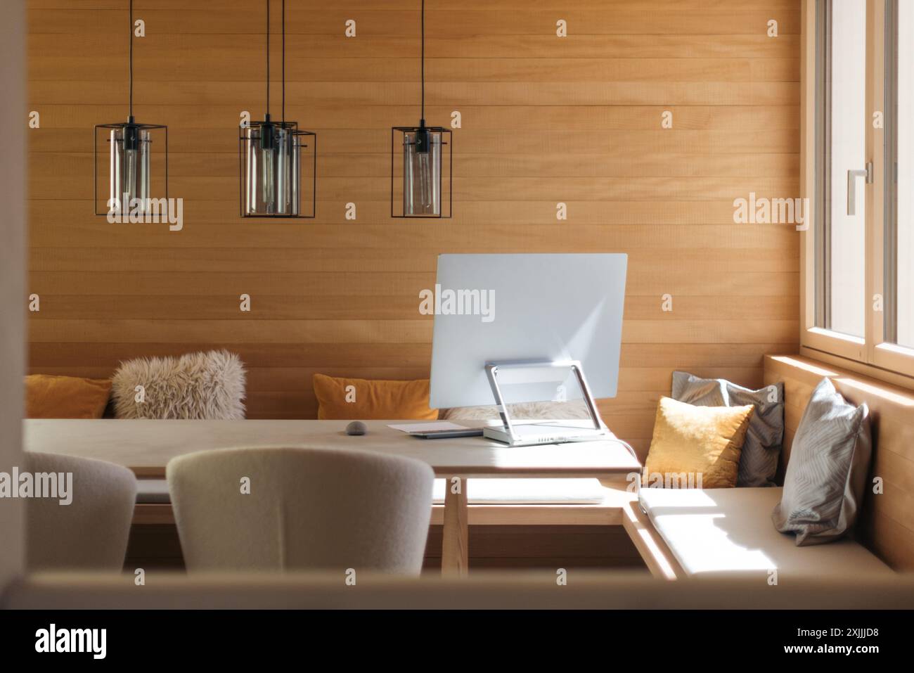 Modern workspace with computer, pendant lights, and cozy seating Stock ...