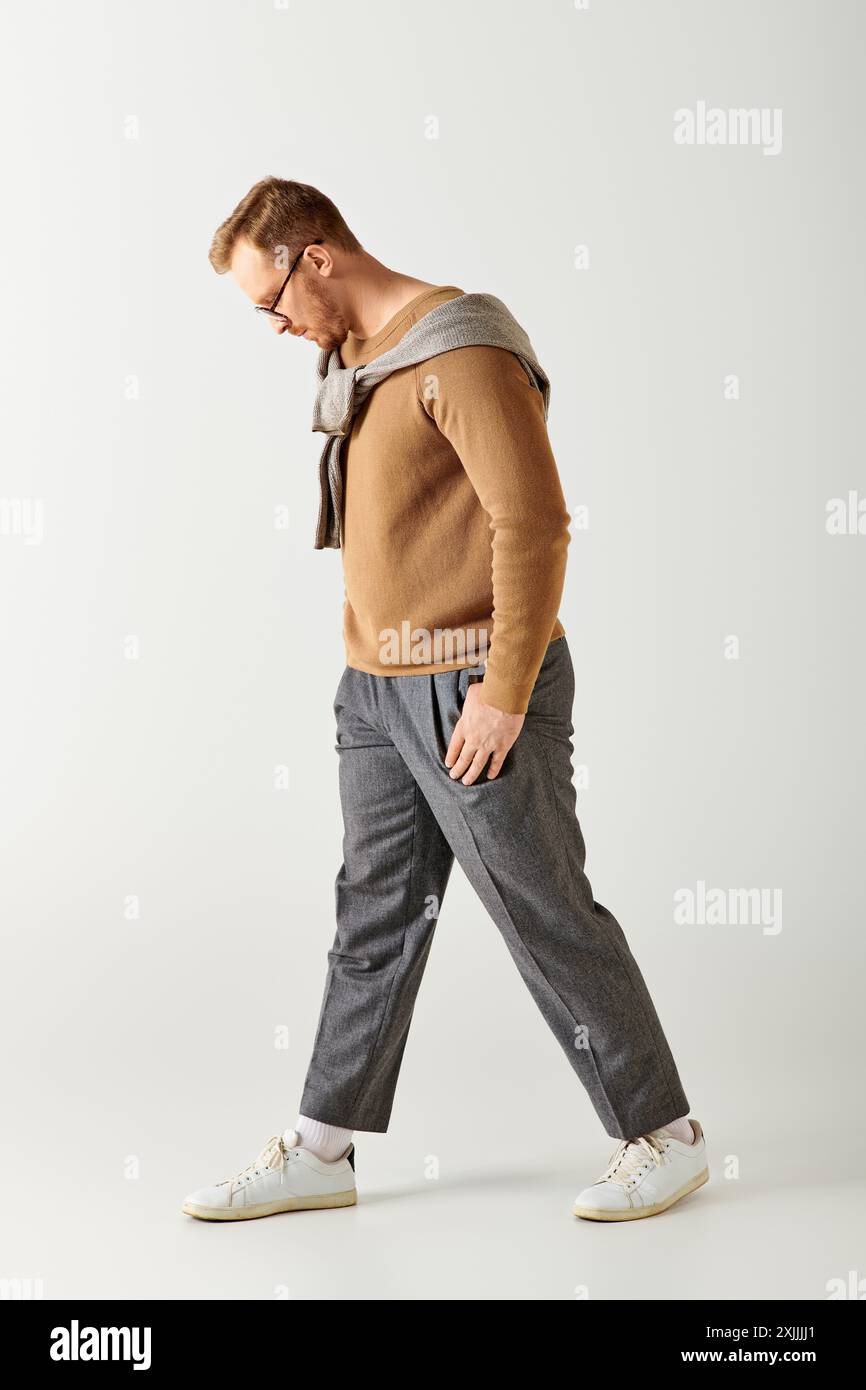 A stylish man walking confidently in a cozy sweater Stock Photo - Alamy