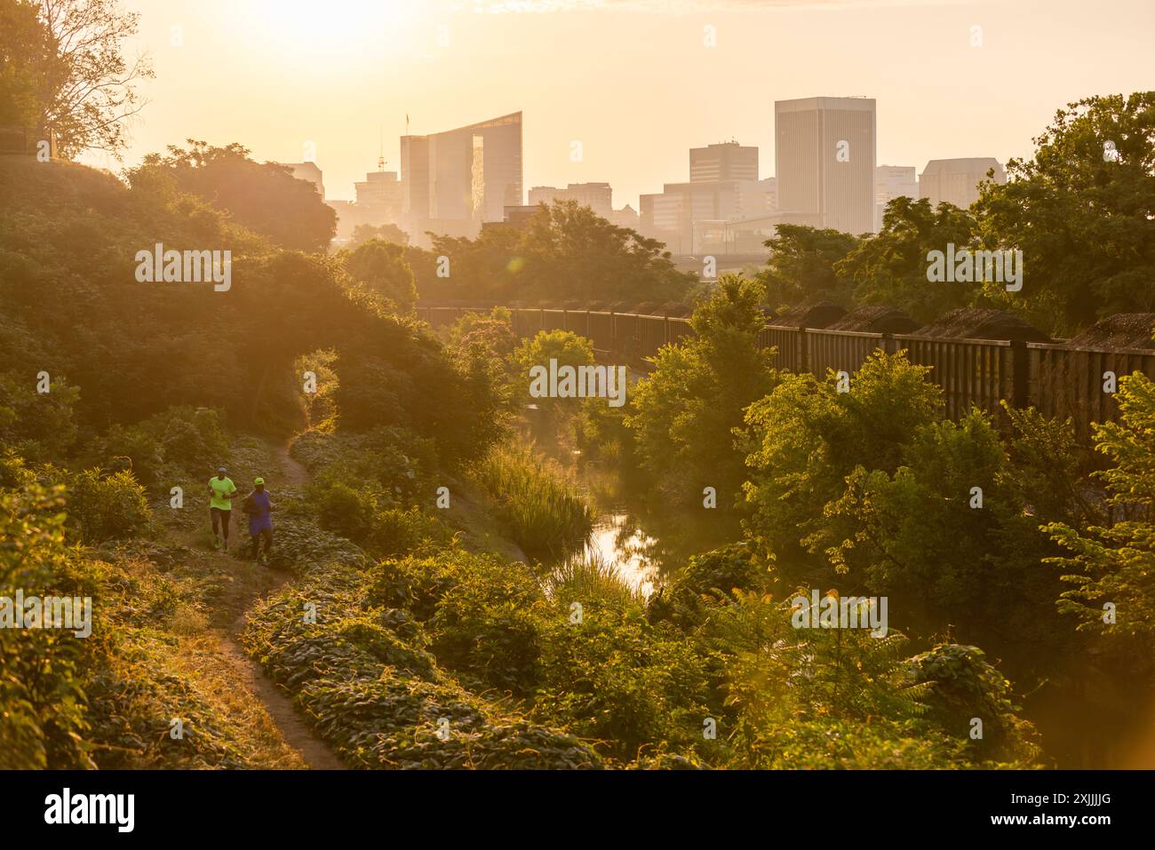 Two friends trail running with a skyline in the background Stock Photo ...
