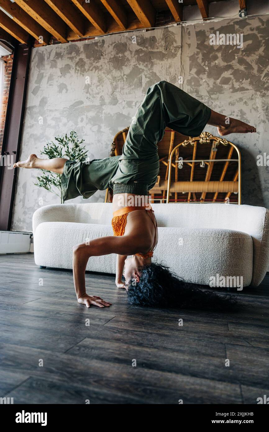 Woman performing a headstand in an artistic, indoor setting Stock Photo ...