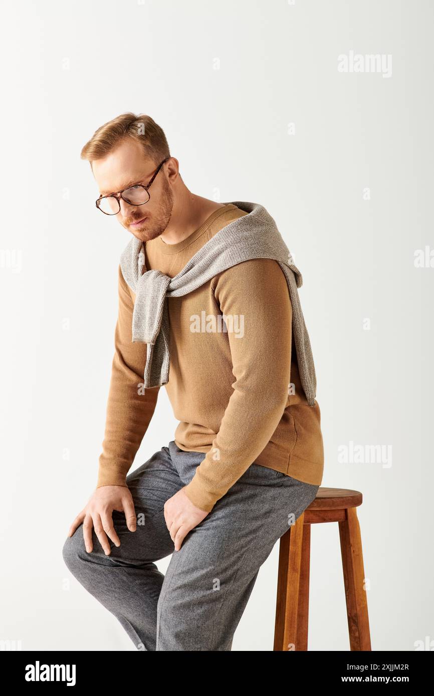 A handsome man in stylish attire actively poses while sitting on top of ...