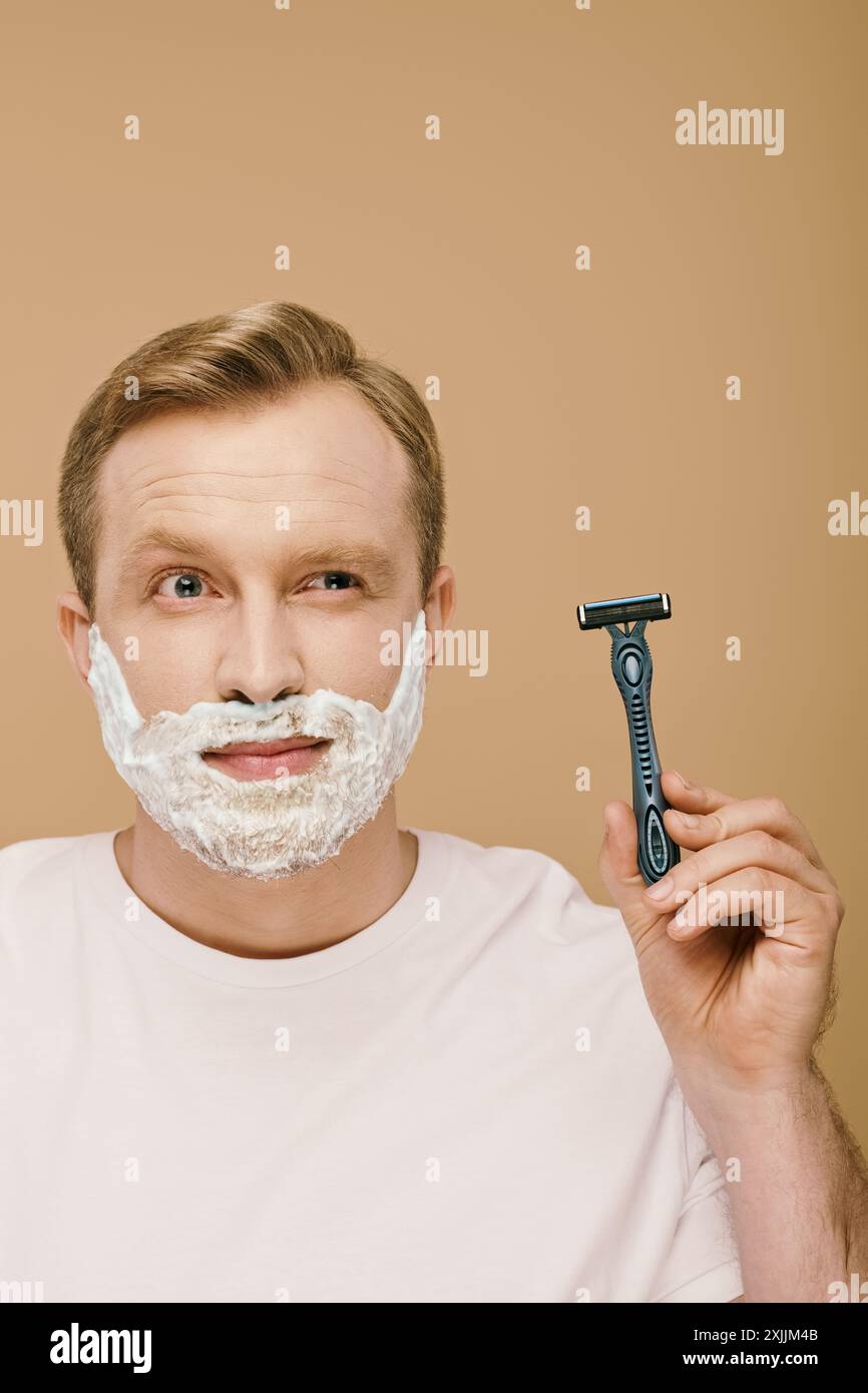 A suave man holding a shaving razor ready for grooming Stock Photo - Alamy