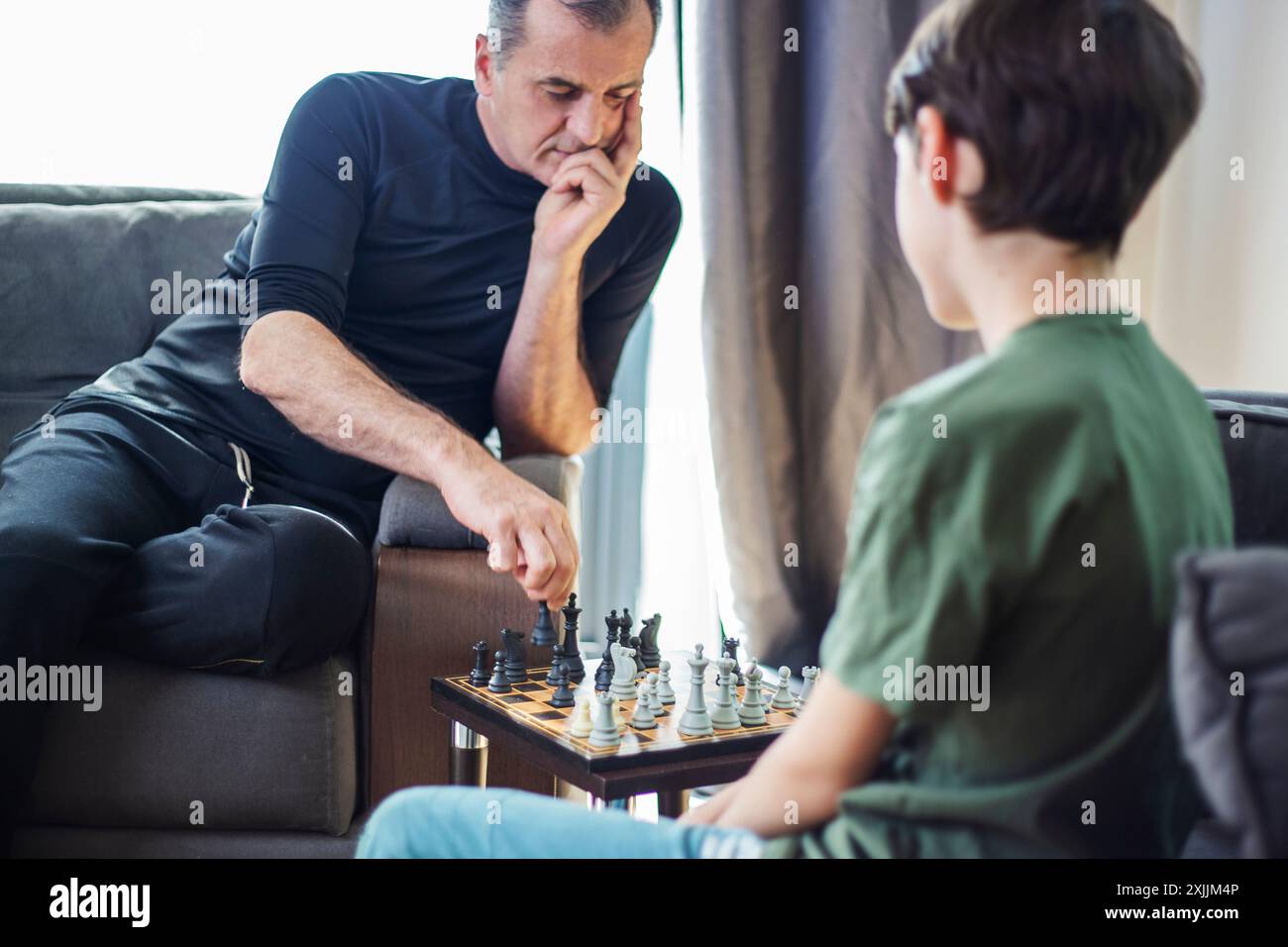Father and son playing chess at home Stock Photo - Alamy