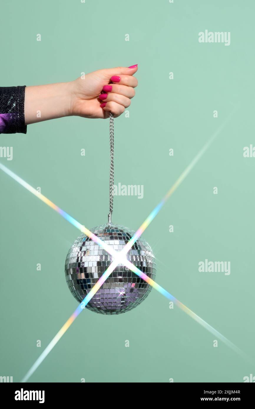 Female hand holding shiny disco ball Stock Photo - Alamy