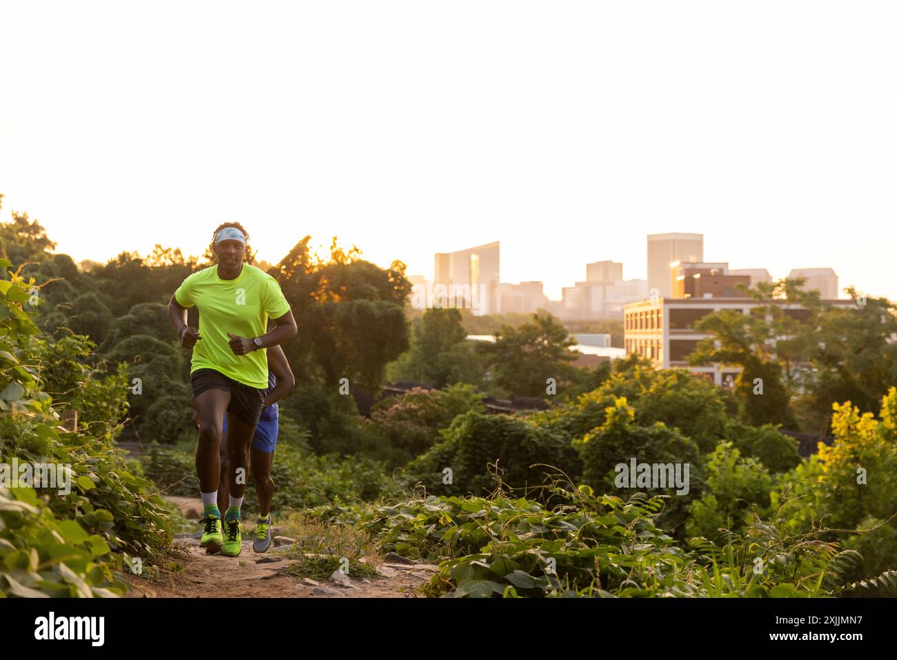 Two friends trail running with a skyline in the background Stock Photo ...