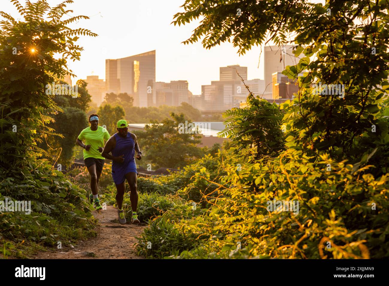 Two friends trail running with a skyline in the background Stock Photo ...