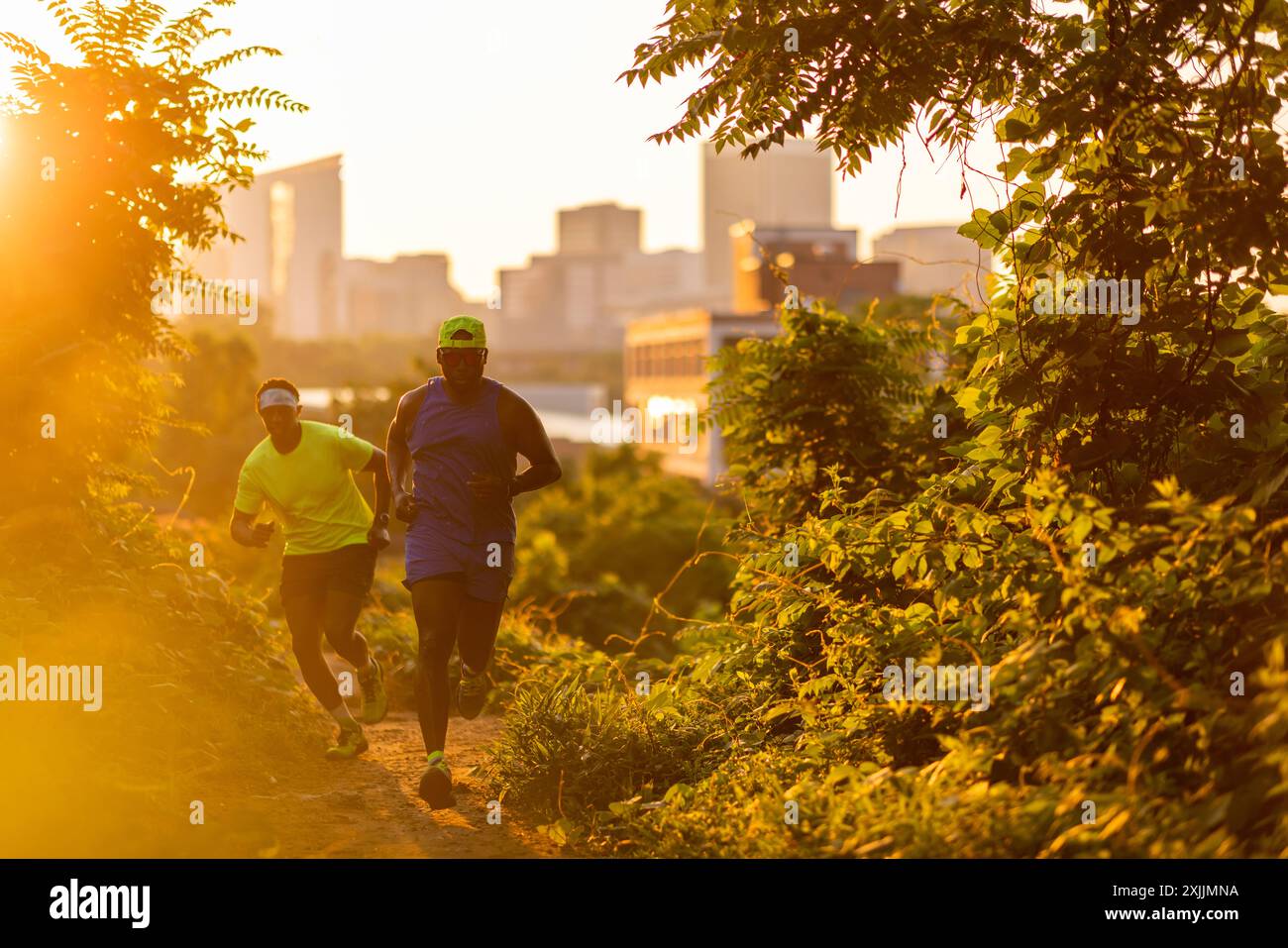 Two friends trail running with a skyline in the background Stock Photo ...