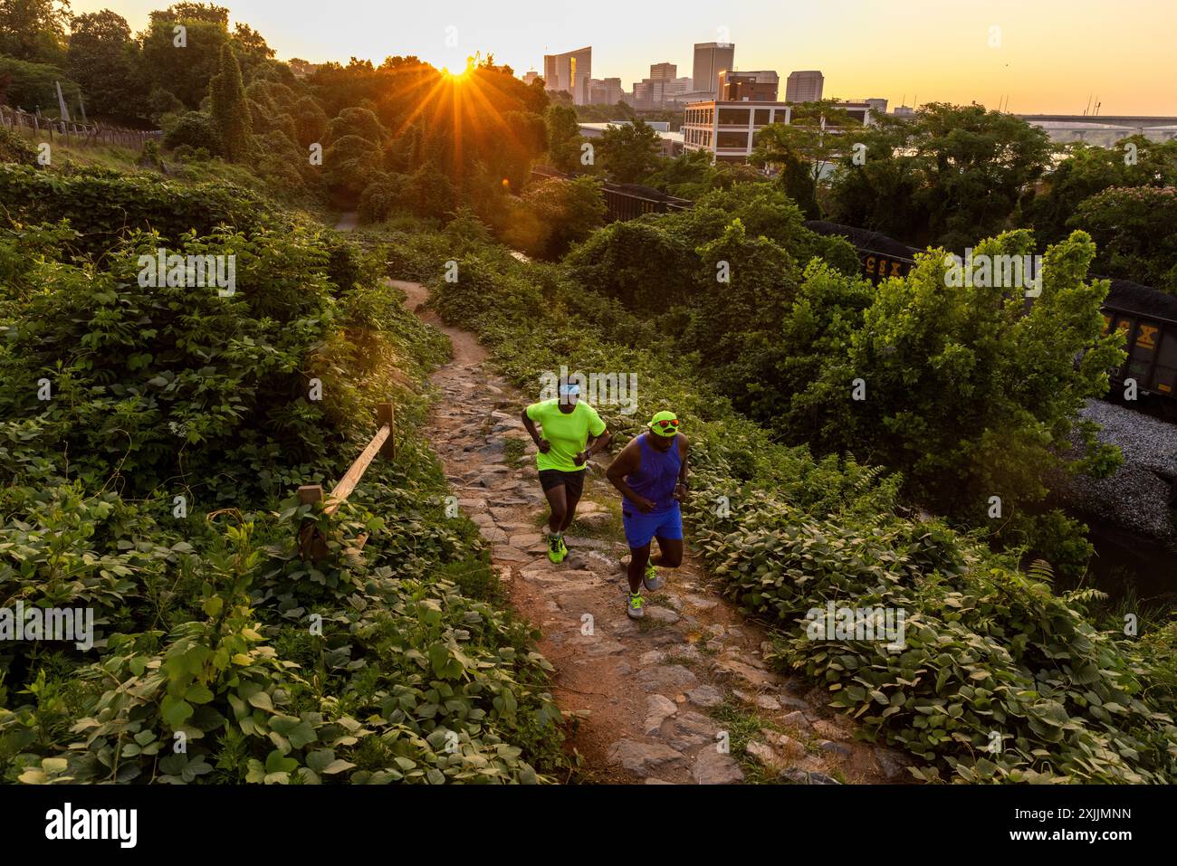 Two friends trail running with a skyline in the background Stock Photo ...