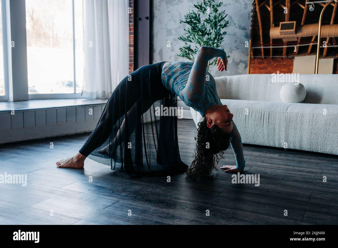 Woman in blue lace top performing a backbend in a stylish studio Stock ...