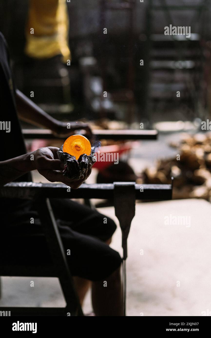 Craftsperson holding blowpipe with molten glass at workshop Stock Photo ...