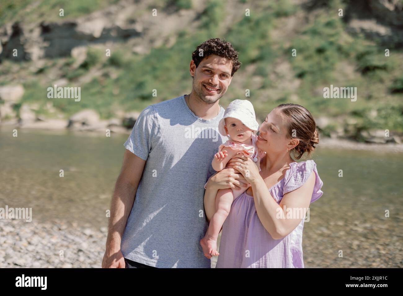 Happy family enjoying a day at the river with their baby Stock Photo ...