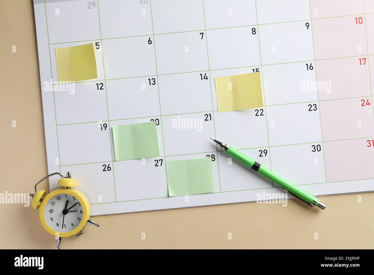 Timetable. Calendar page with sticky notes, pen and alarm clock on ...