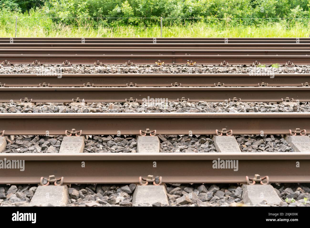 Pattern of five railway tracks on gravel as a side view. Fence runnimg ...