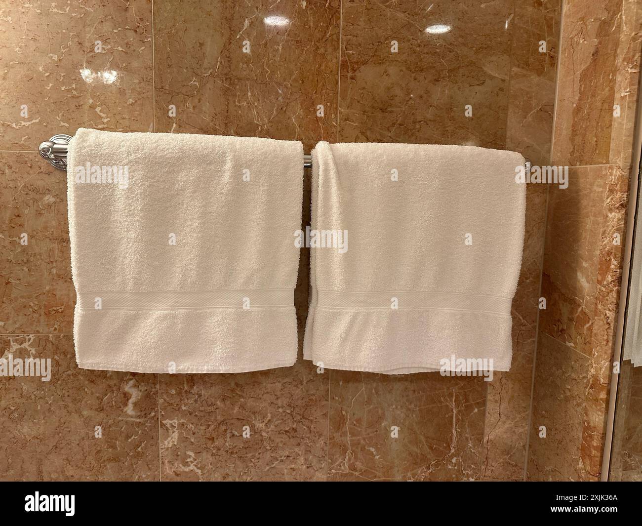 Soft terry towels hanging on tiled wall in hotel bathroom Stock Photo ...