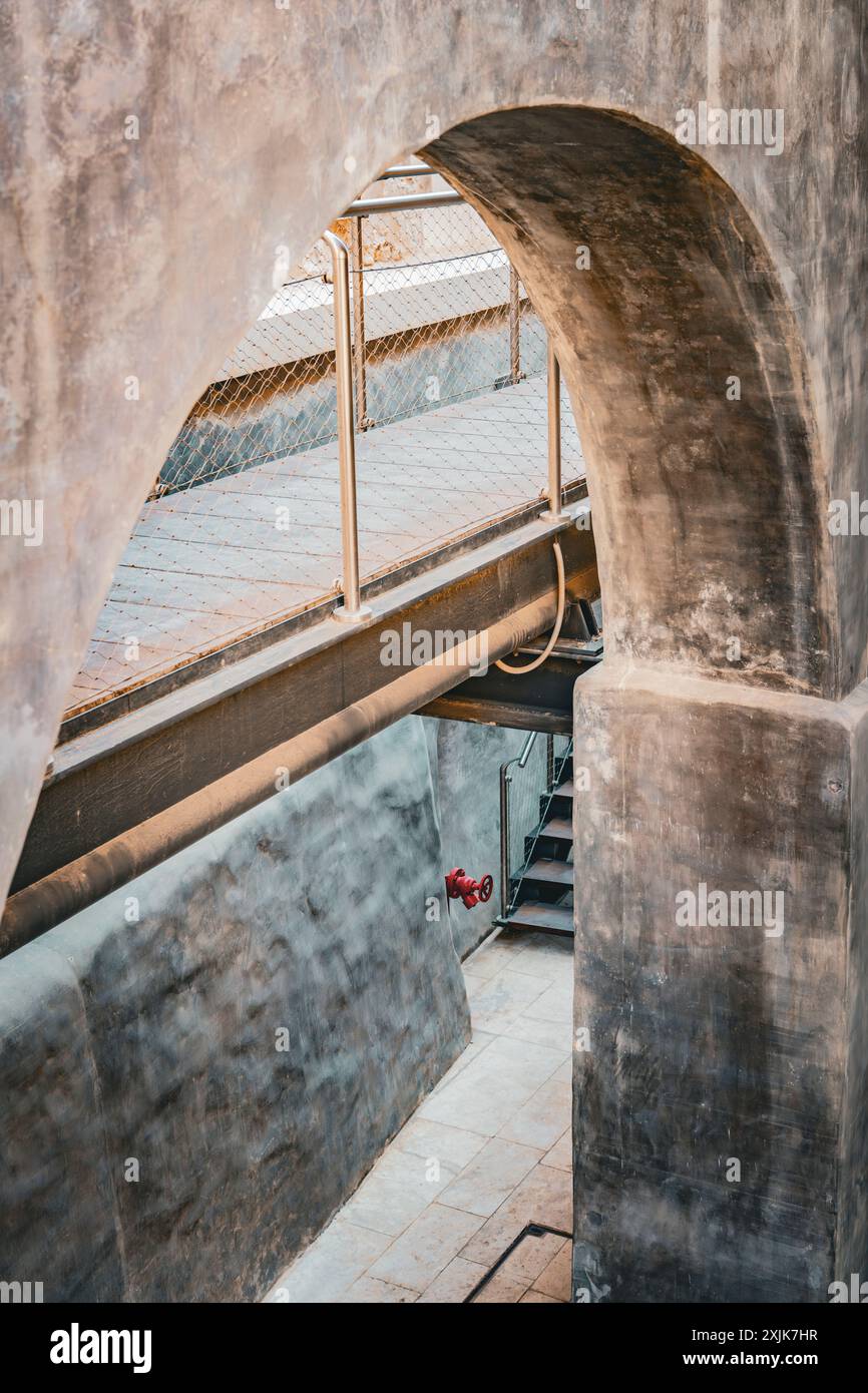 A modern industrial setting featuring a metal walkway with a railing ...