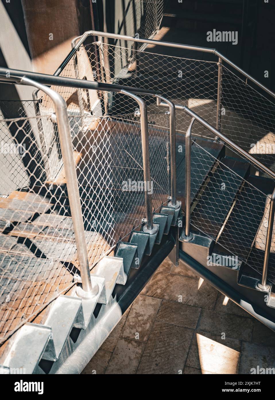 Industrial-style metal staircase with wire mesh railing, casting ...