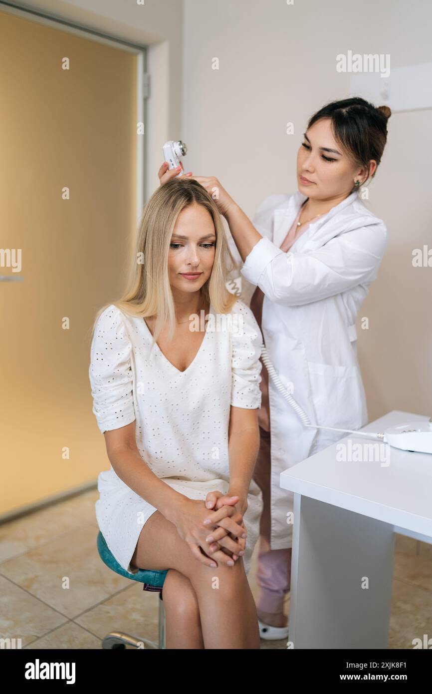 Vertical shot of female trichologist making diagnosis of structure and ...