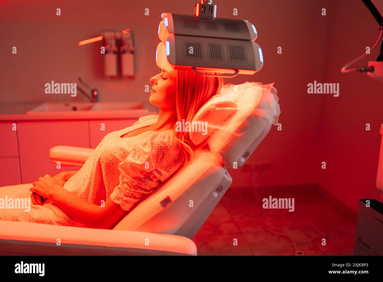 Side view portrait of blonde female lying on procedure chair having LED ...