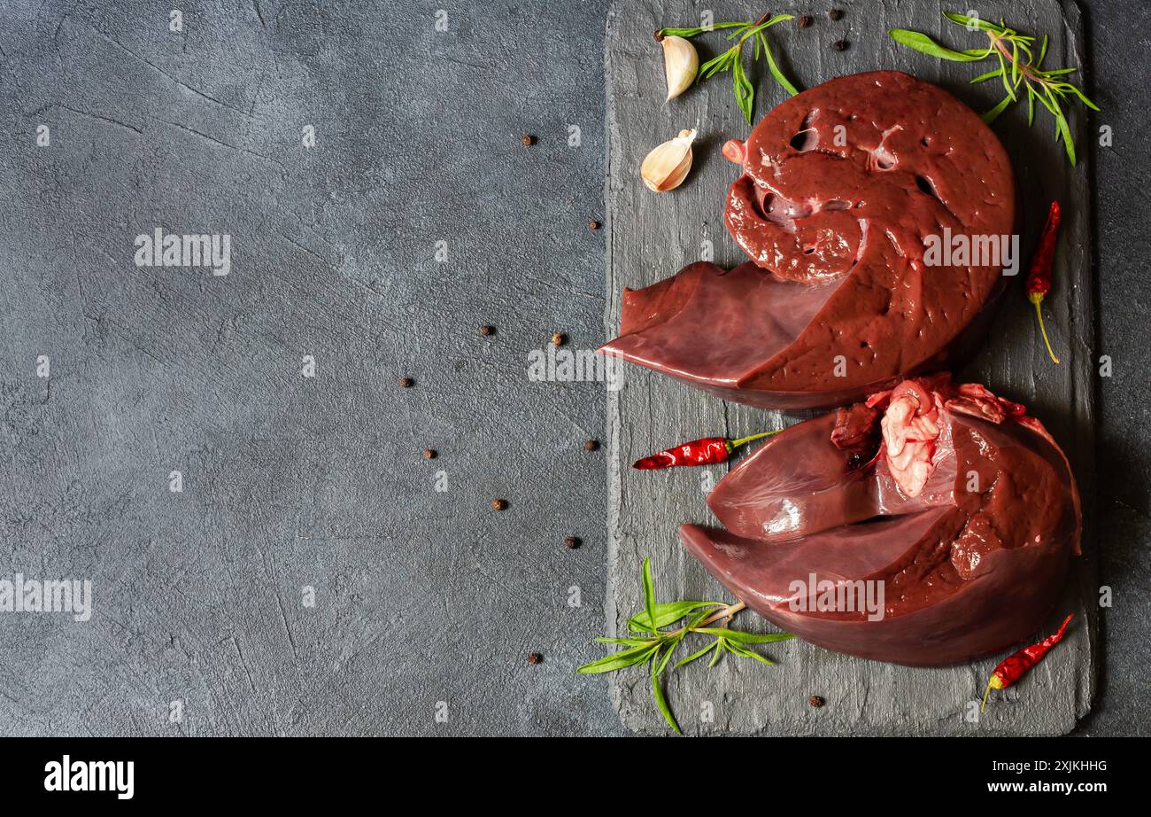 Raw Beef liver meat on stone board with thyme and black peppers, cattle ...