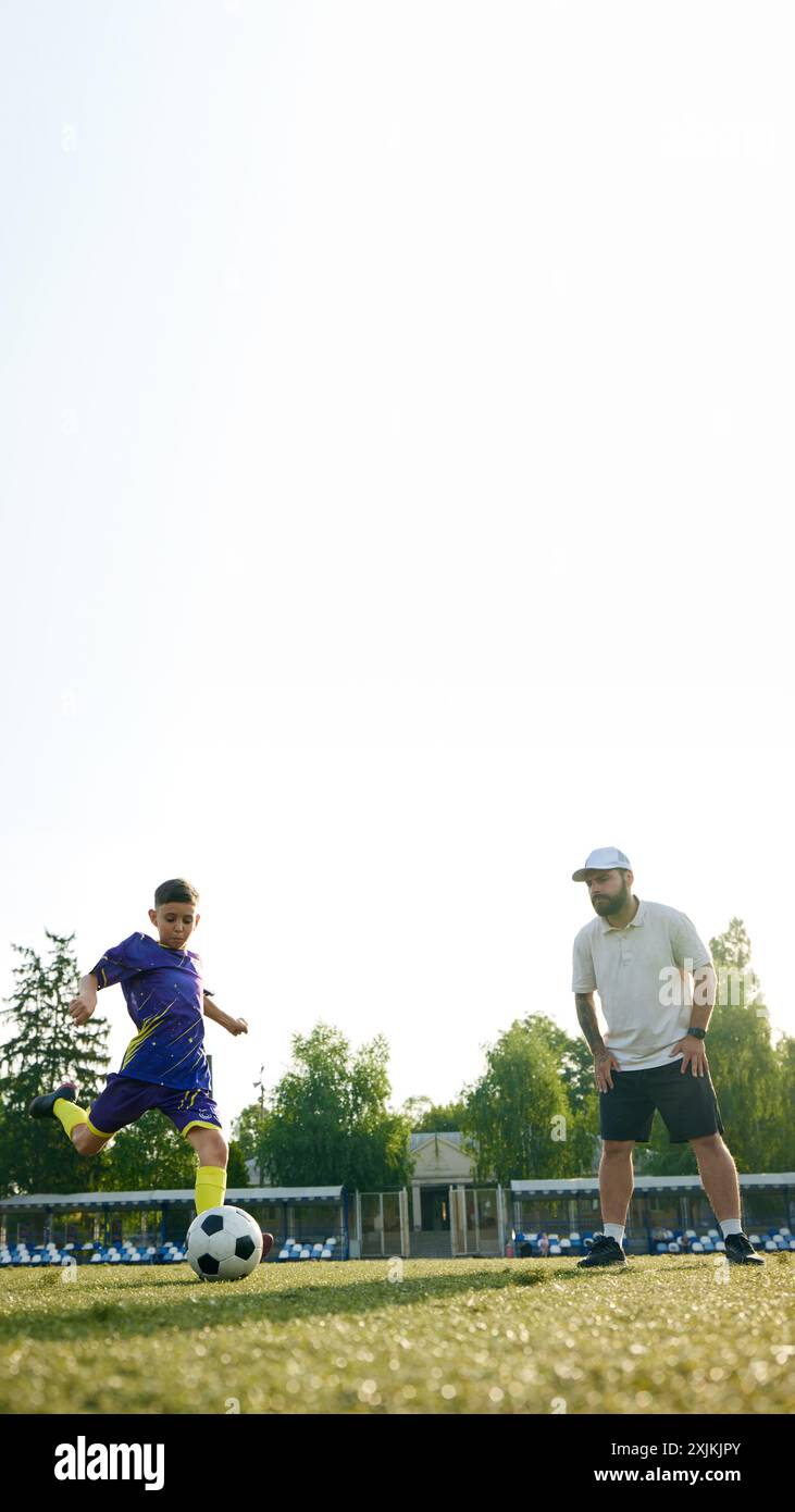 Young athlete striking soccer ball with determination, while coach ...