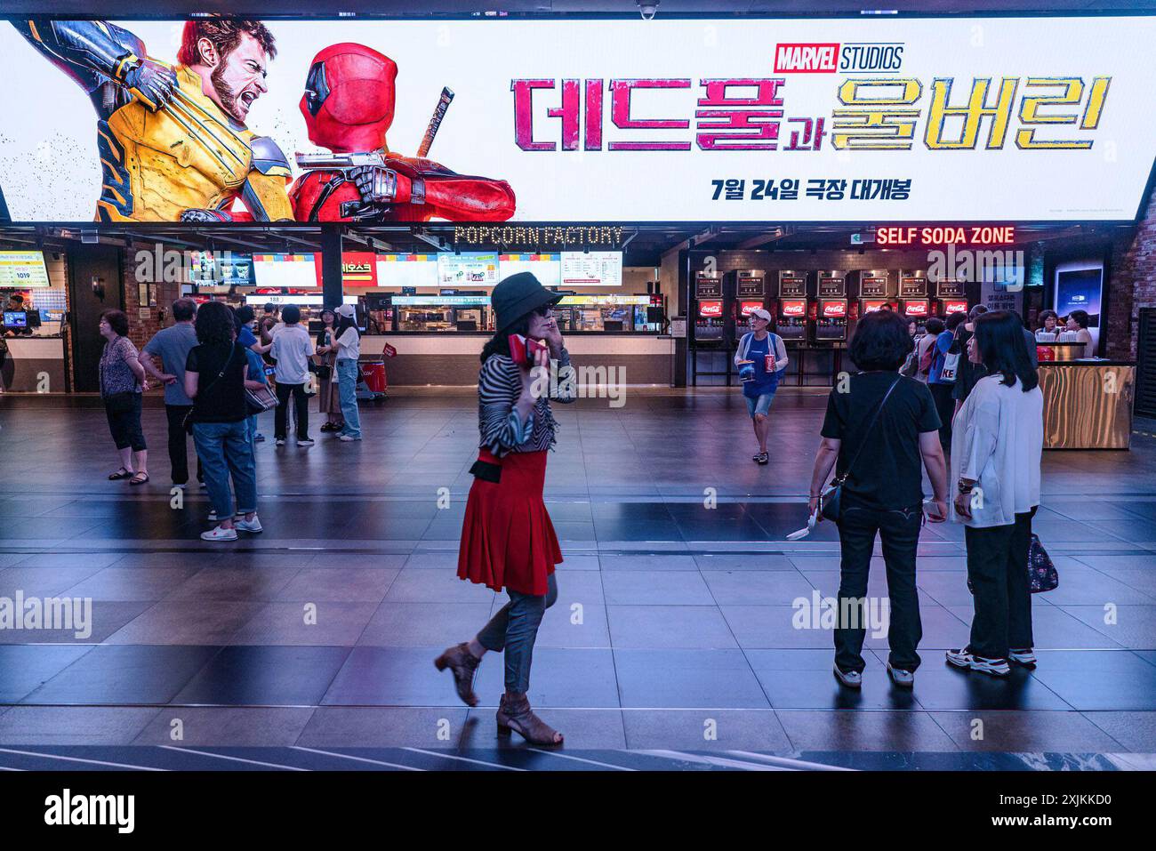 Seoul, South Korea. 19th July, 2024. People walk past a billboard of ...