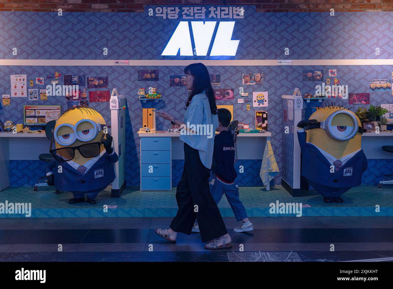 Seoul, South Korea. 19th July, 2024. A woman and a child walk past a ...
