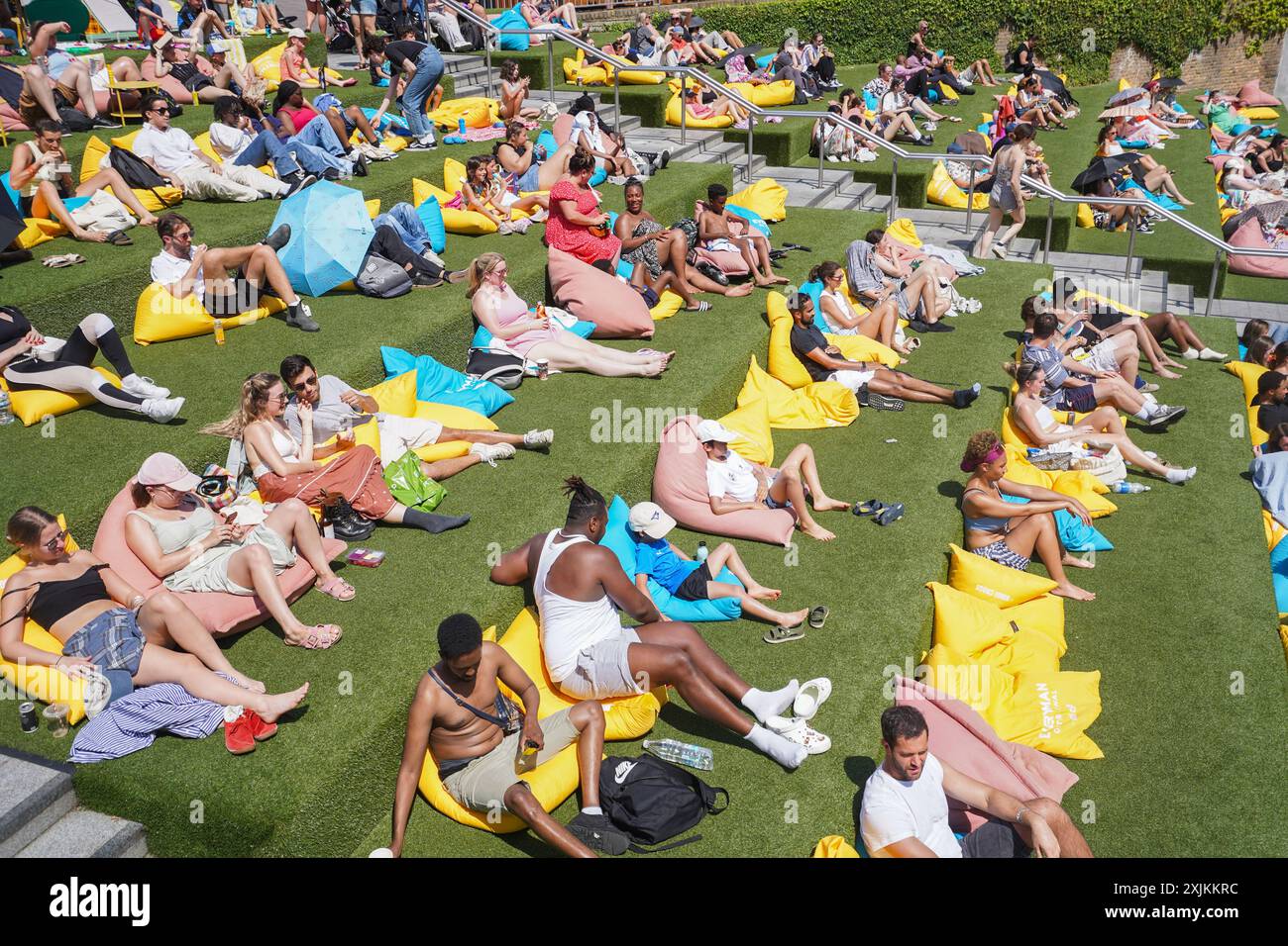 London, UK. 19 July 2024 People enjoying the sunshine in Granary Square ...