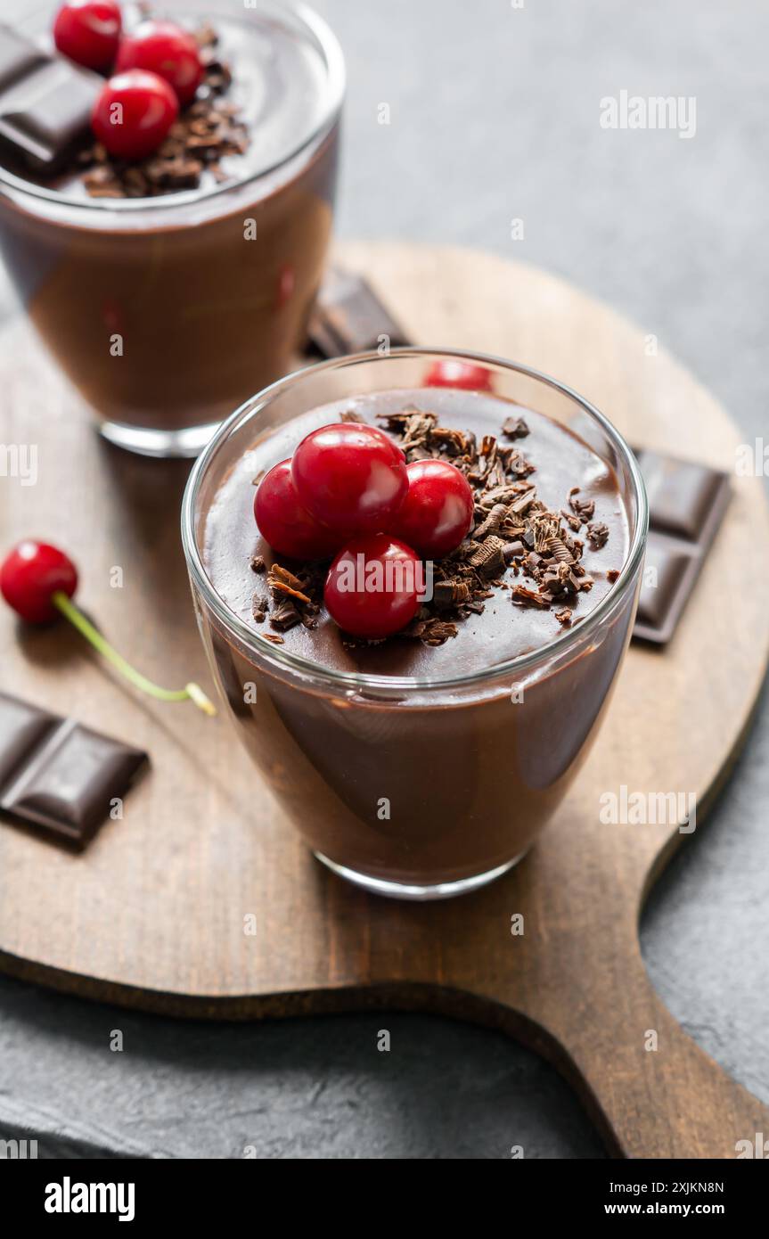 Chocolate cocoa pudding with sour cherry, mousse in glass cup on rustic ...