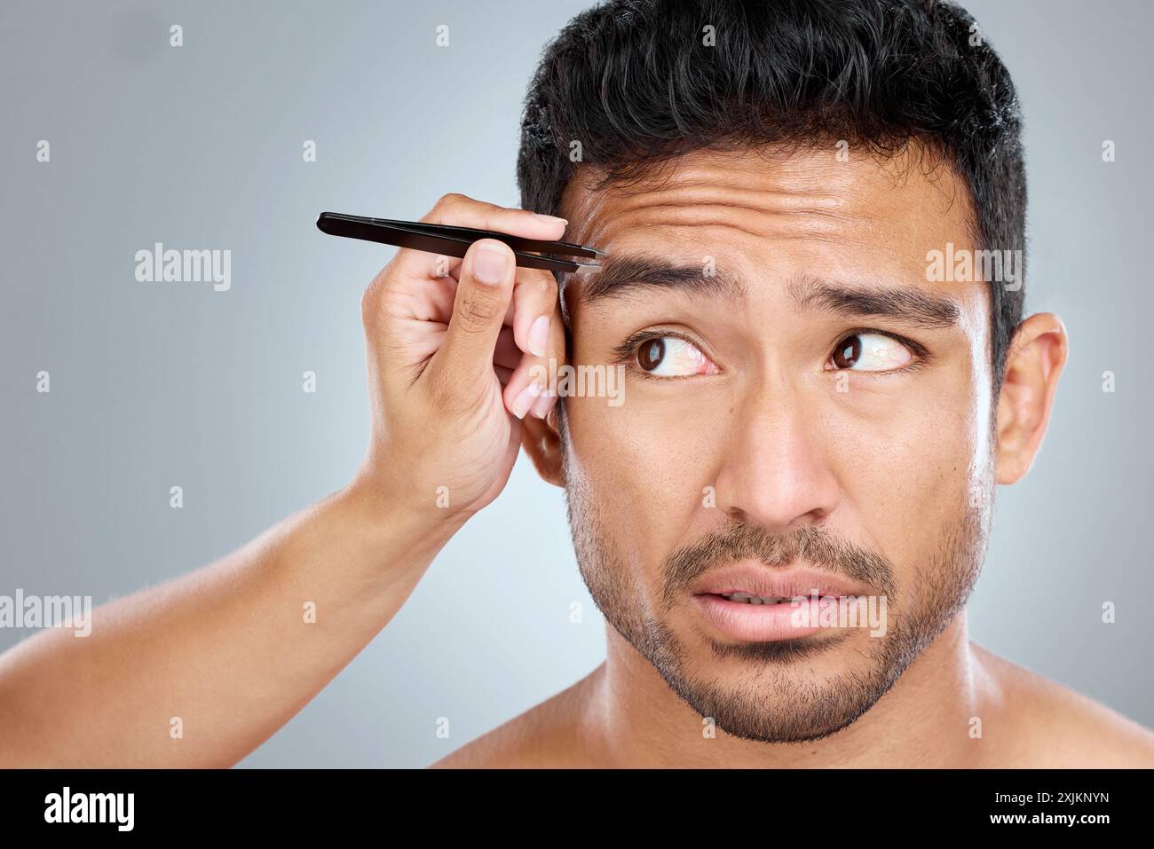 Man, hand and tweezers by eyebrow in studio for grooming, facial ...