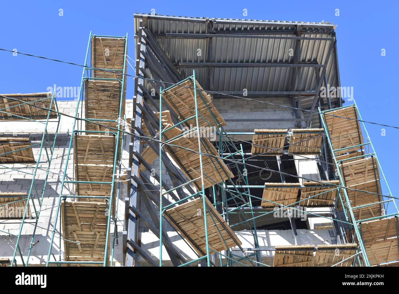 Brick monolithic building under construction with wooden scaffolding ...