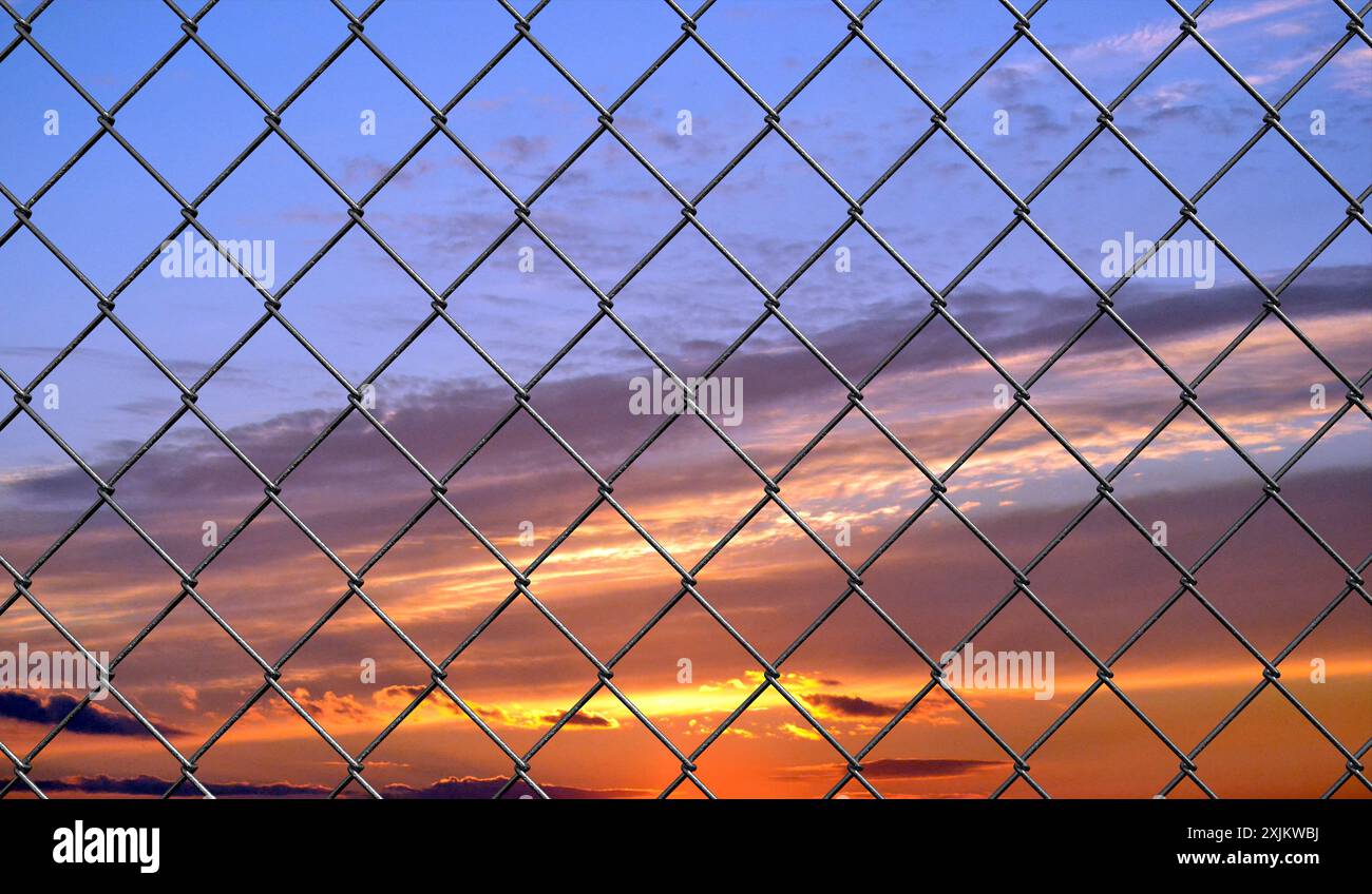 Mesh wire fence and sunset sky - 3d illustration Stock Photo - Alamy