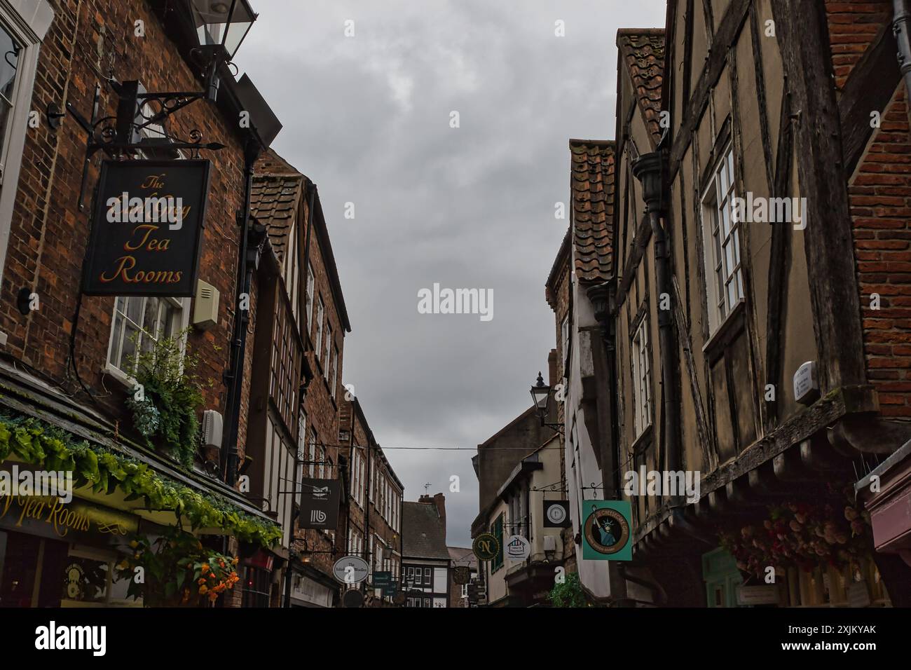 A narrow street in a historic town with old brick and timber-framed ...